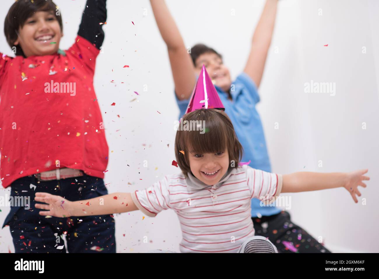 Happy kids celebrating party with blowing confetti Stock Photo - Alamy