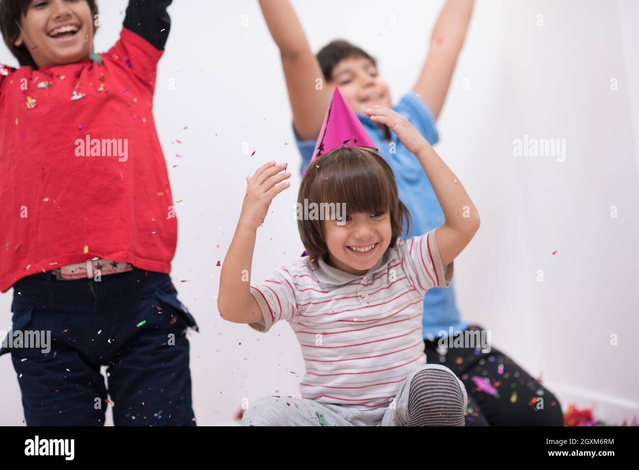 Happy kids celebrating party with blowing confetti Stock Photo - Alamy