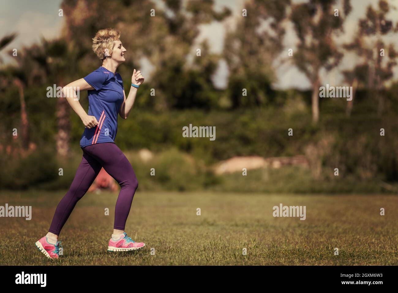young sporty female runner training for marathon running at beautiful ...