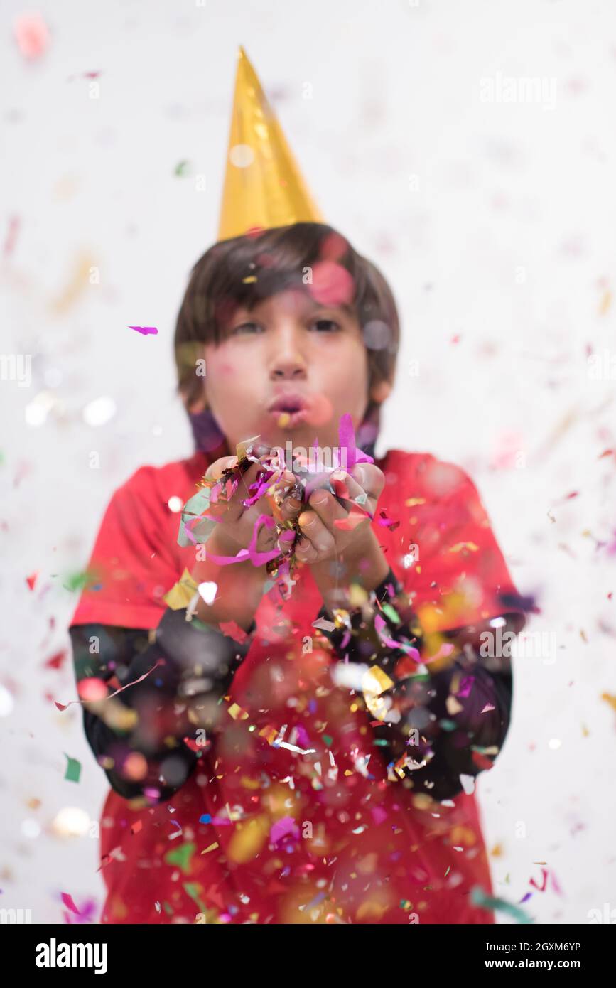 Happy kid celebrating party with blowing confetti Stock Photo - Alamy