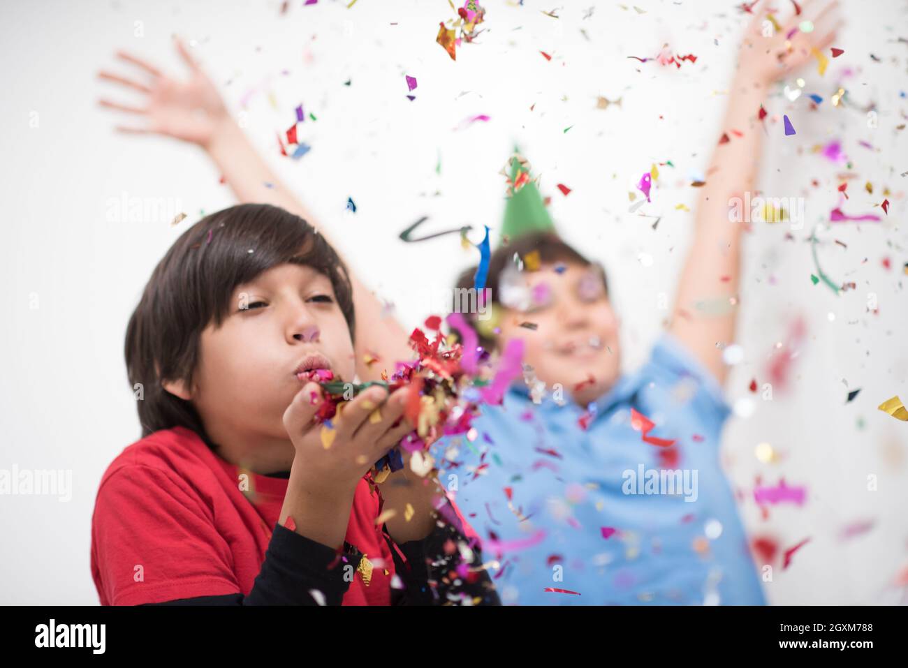 Happy kids celebrating party with blowing confetti Stock Photo - Alamy