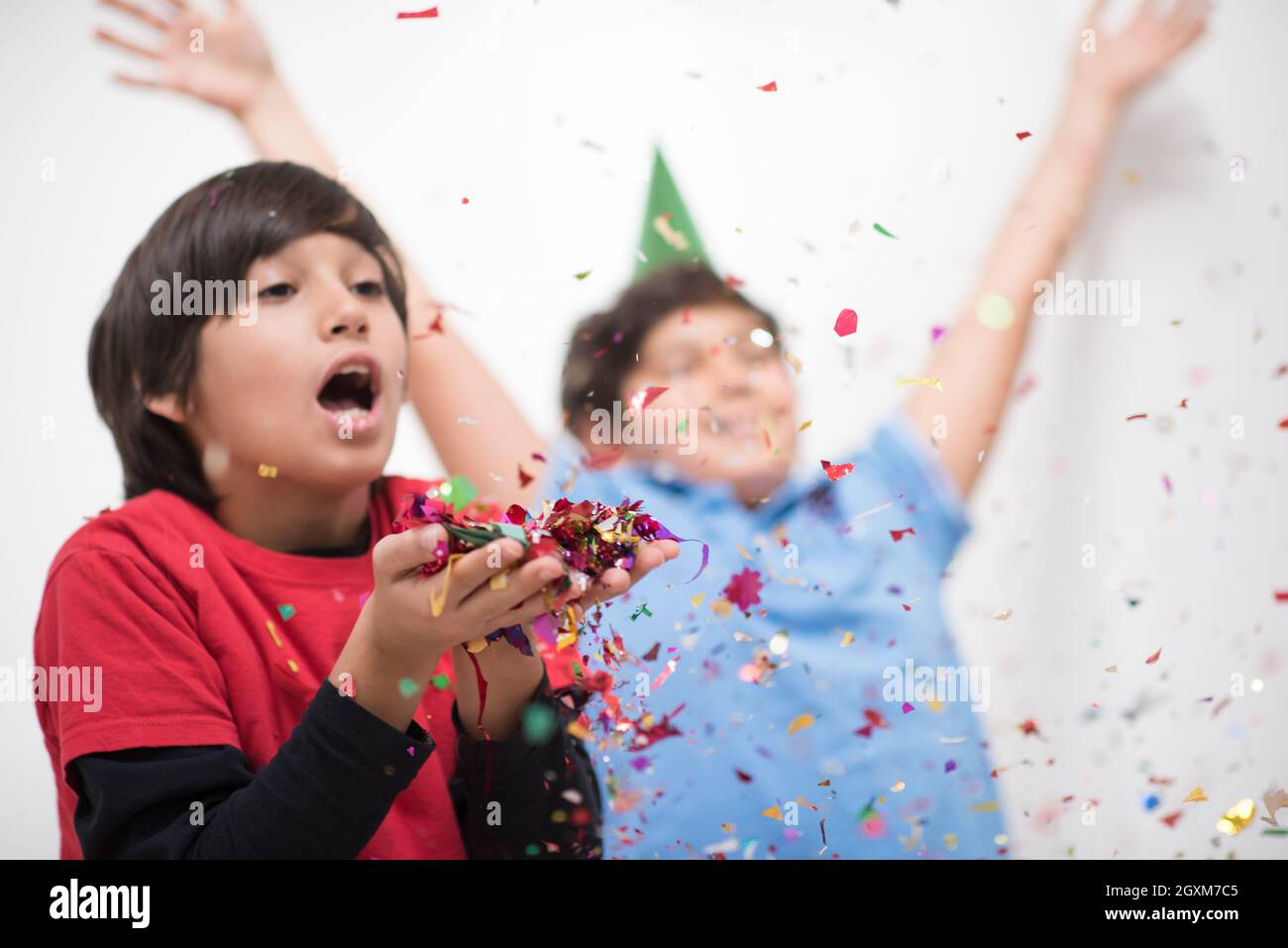 Happy kids celebrating party with blowing confetti Stock Photo - Alamy