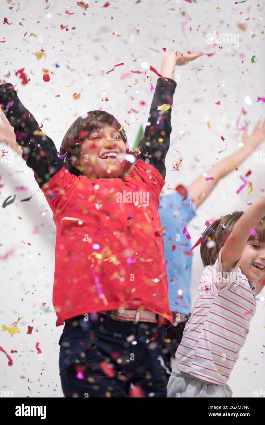 Happy kids celebrating party with blowing confetti Stock Photo - Alamy