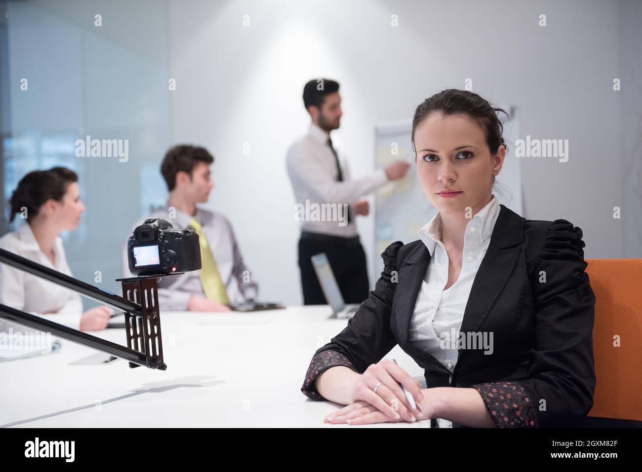 young business woman on meeting usineg laptop computer, blured group of ...
