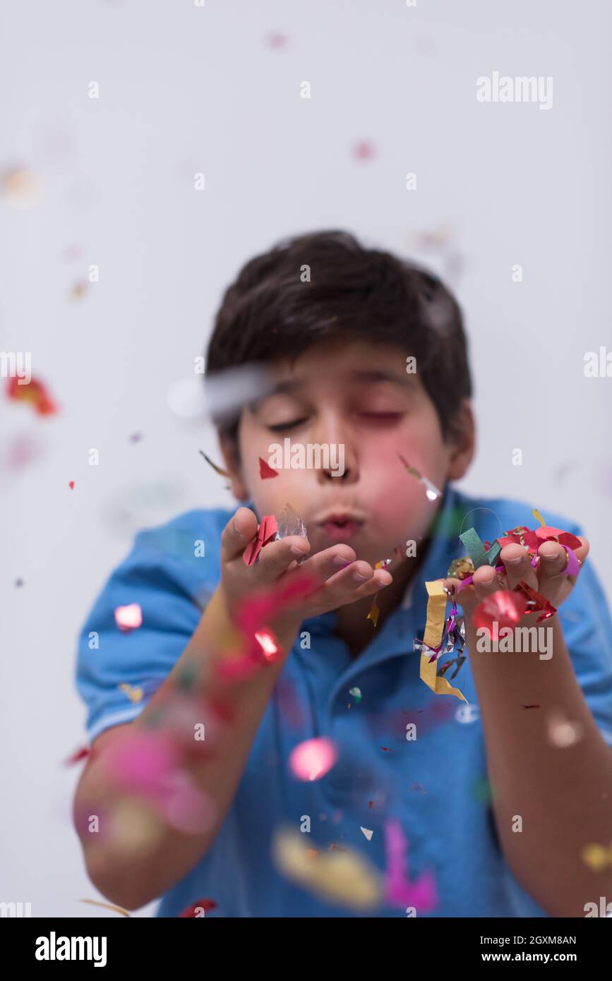 Happy kid celebrating party with blowing confetti Stock Photo - Alamy