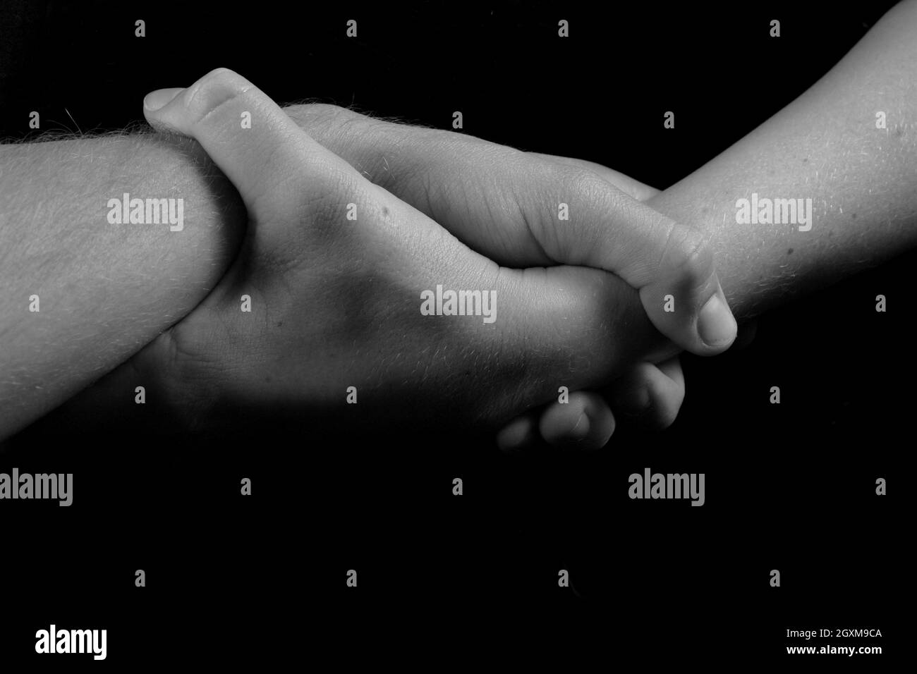 Black and white shot of two hands clasped together at the wrist Stock ...