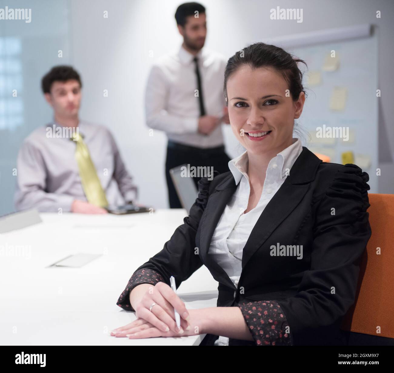 young business woman on meeting usineg laptop computer, blured group of ...