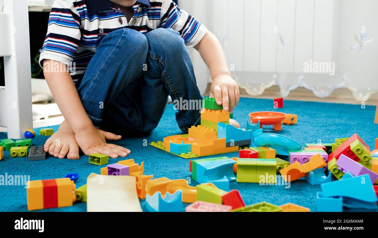 Closeup image of little boy building a house with colorful constructor ...