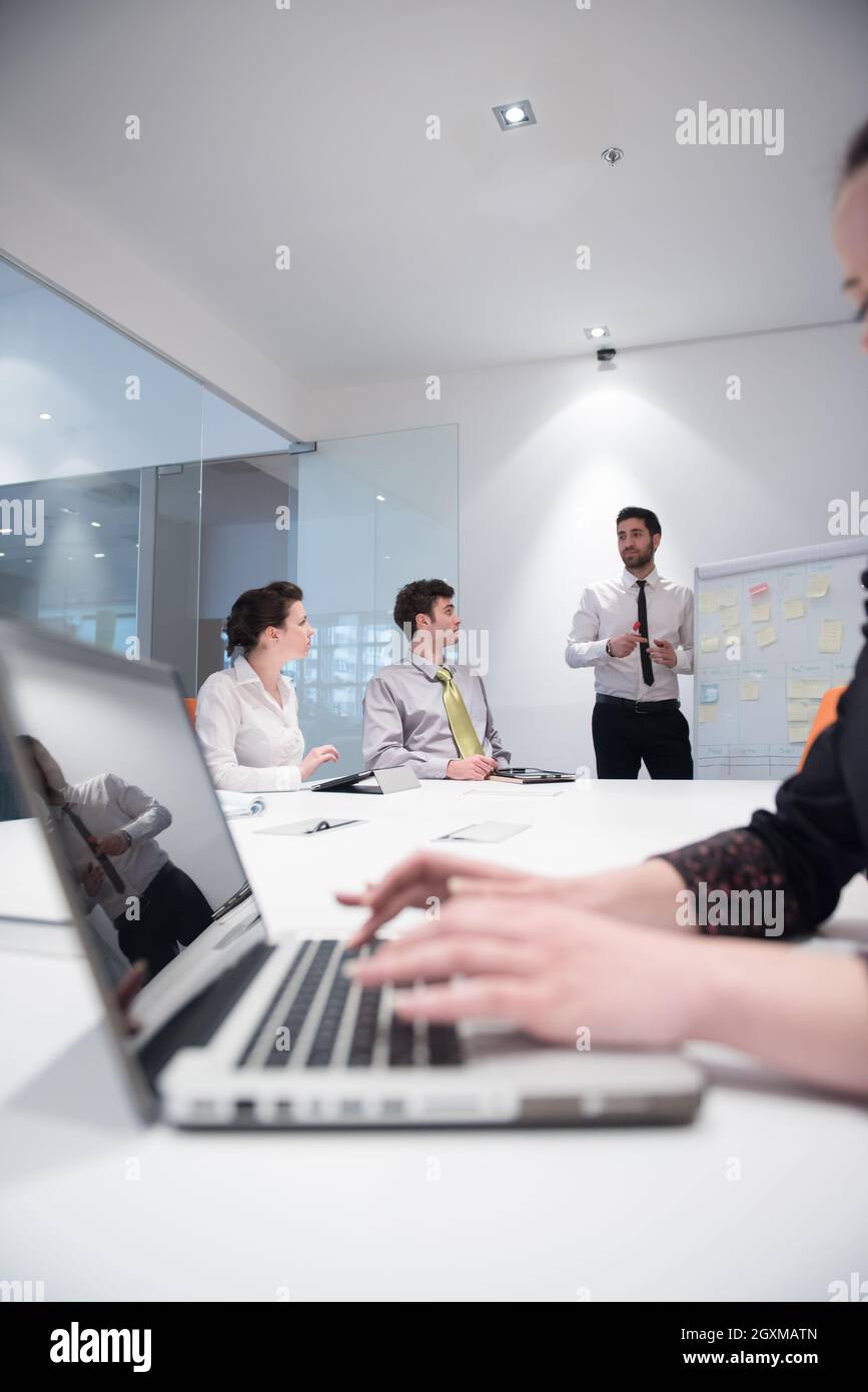 young business woman on meeting usineg laptop computer, blured group of ...