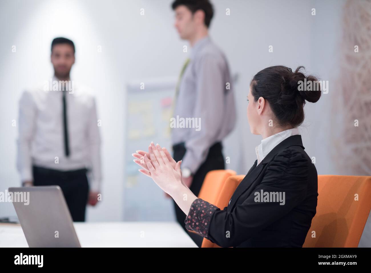young business woman on meeting usineg laptop computer, blured group of ...