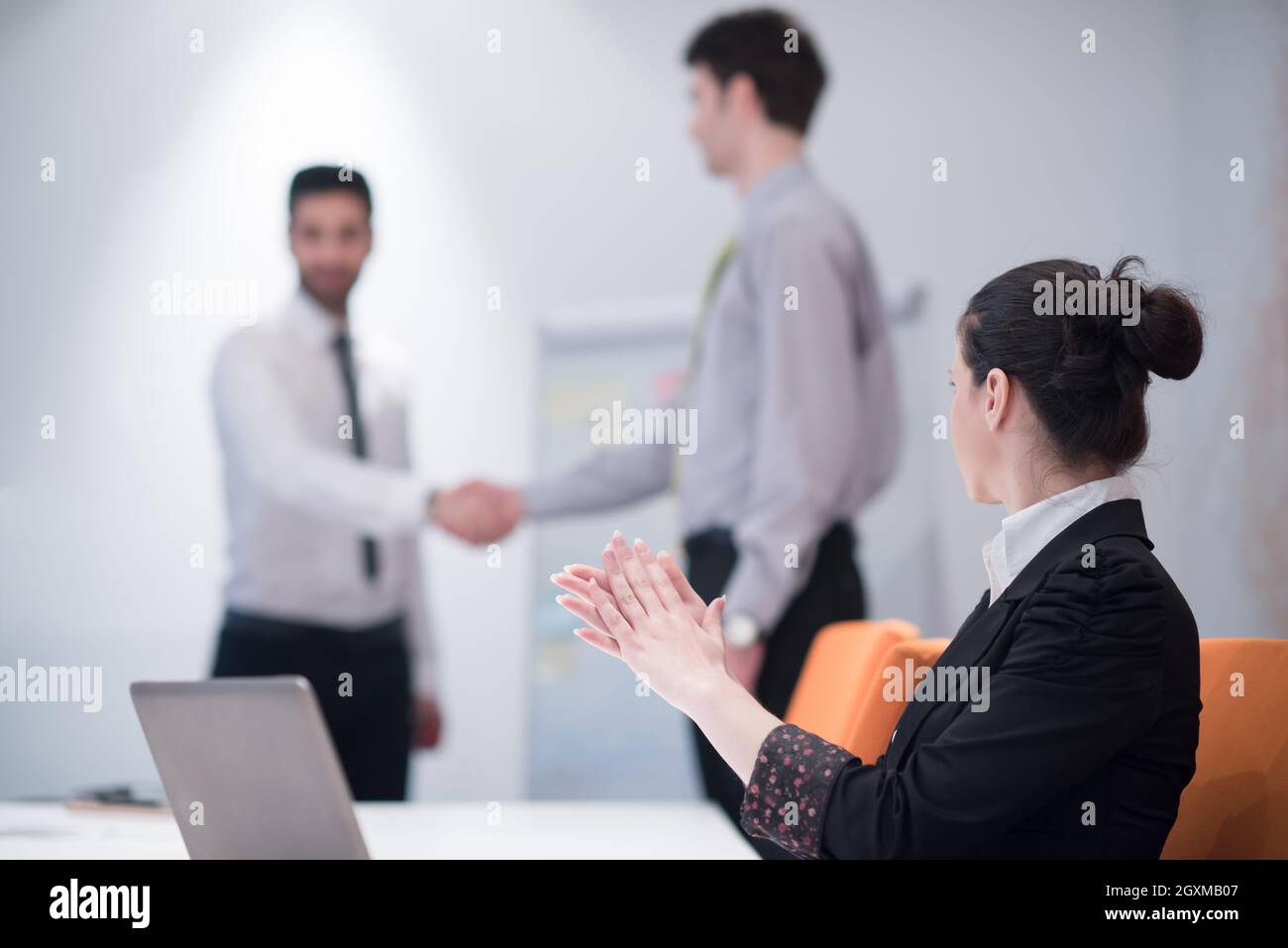 young business woman on meeting usineg laptop computer, blured group of ...