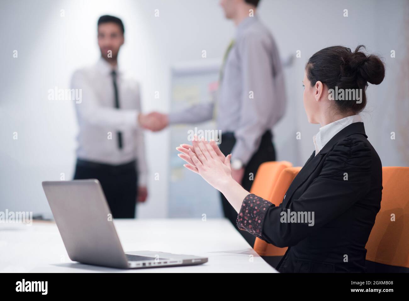 young business woman on meeting usineg laptop computer, blured group of ...