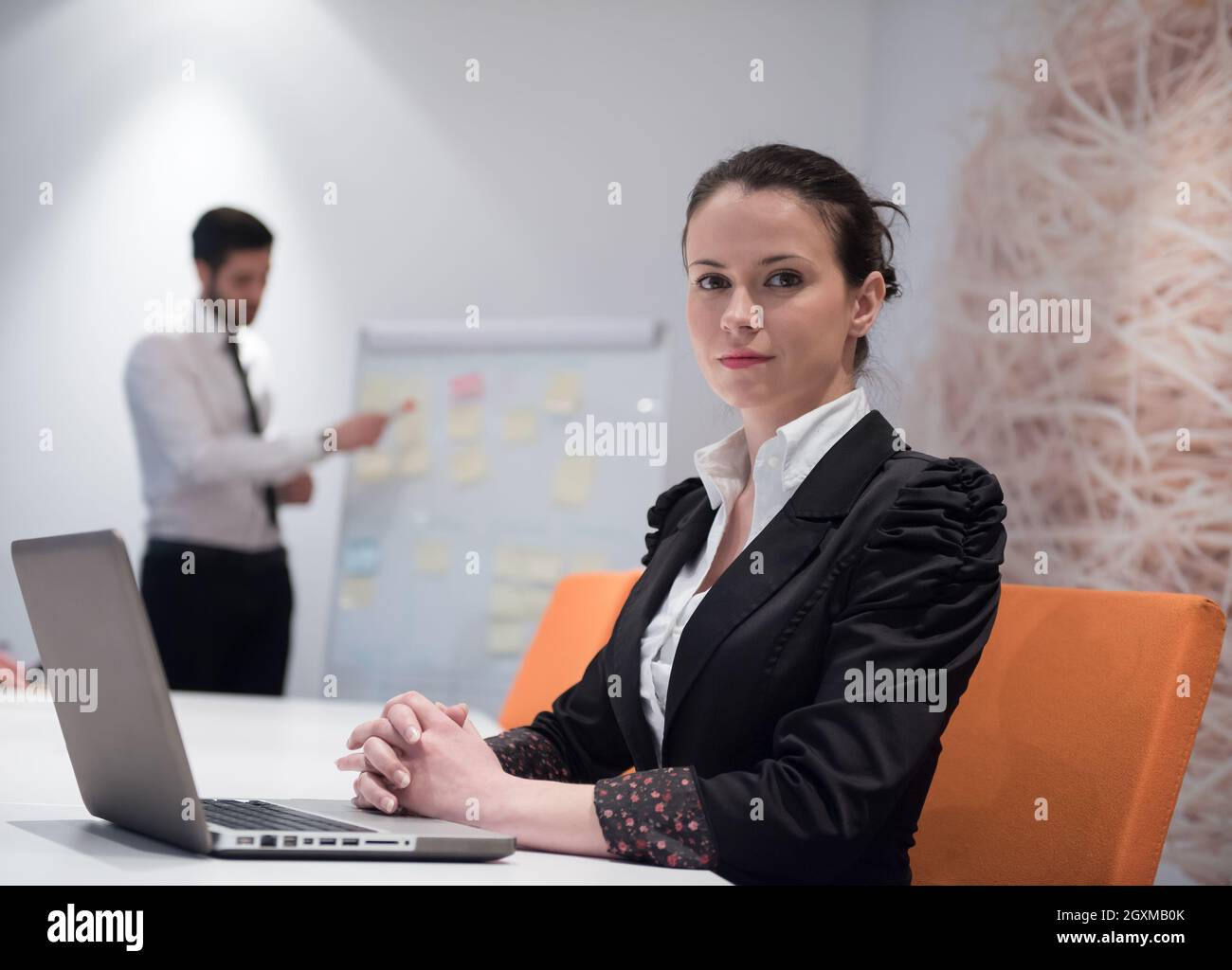 young business woman on meeting usineg laptop computer, blured group of ...