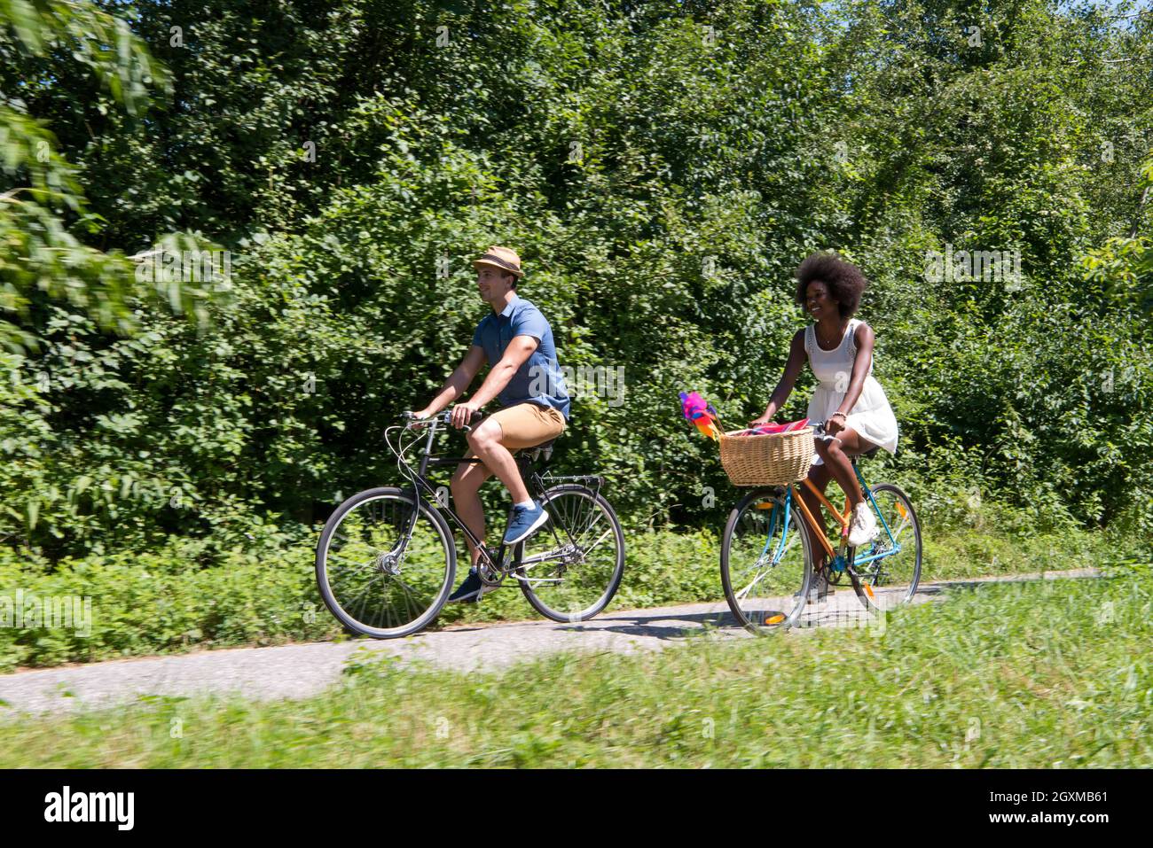 a young man and a beautiful African American girl enjoying a bike ride ...