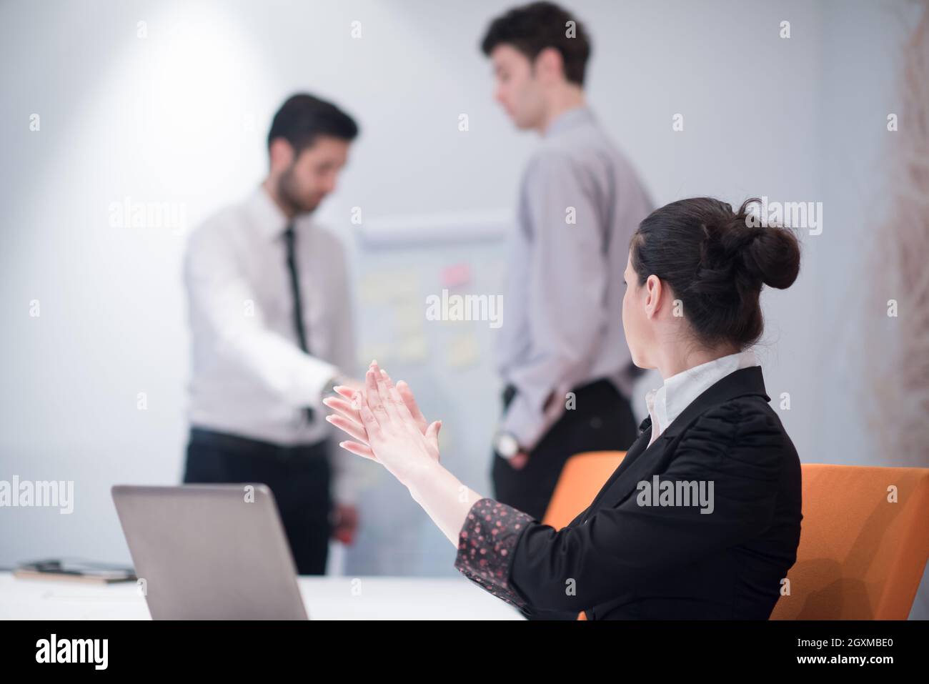 young business woman on meeting usineg laptop computer, blured group of ...