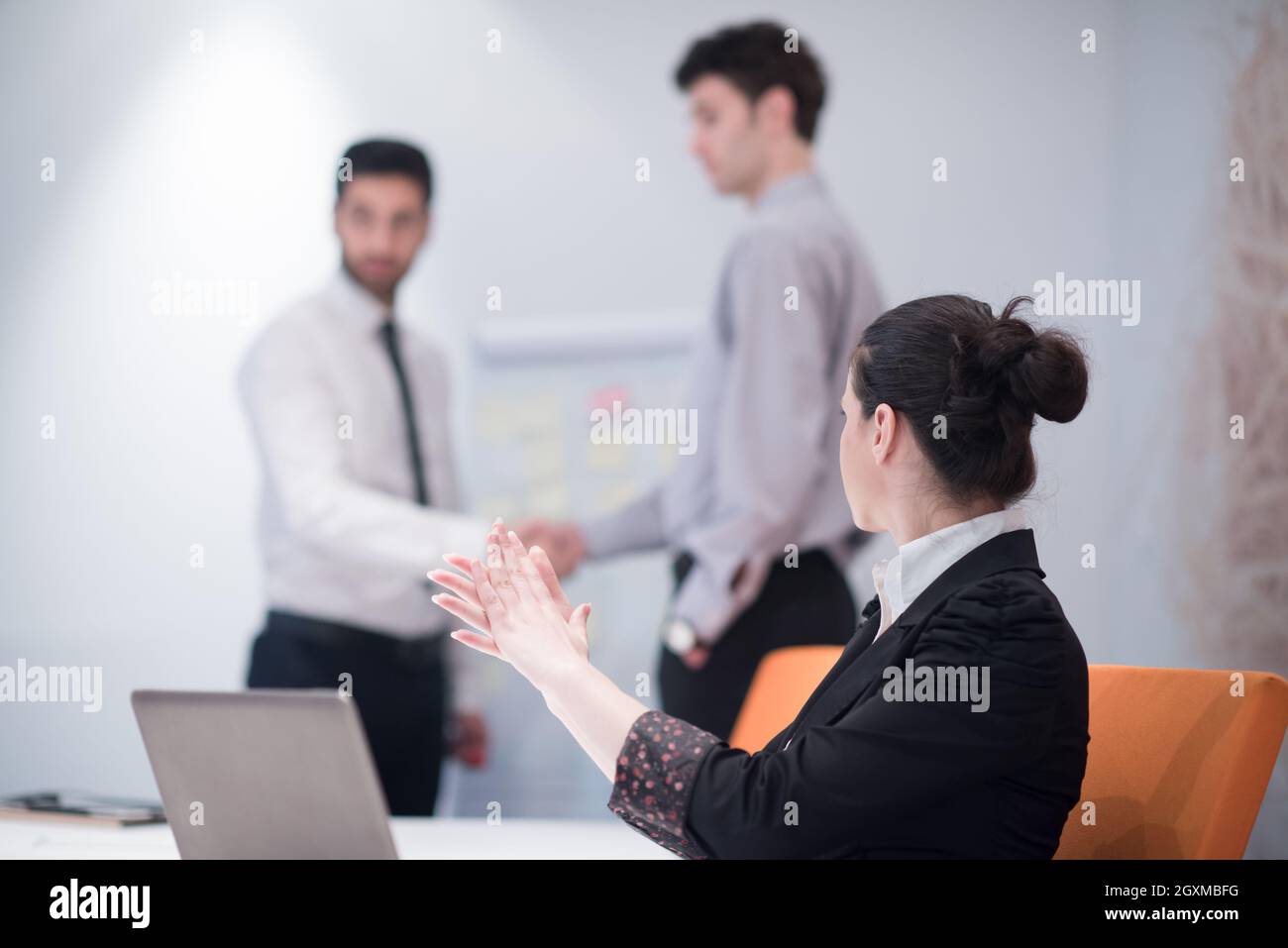 young business woman on meeting usineg laptop computer, blured group of ...