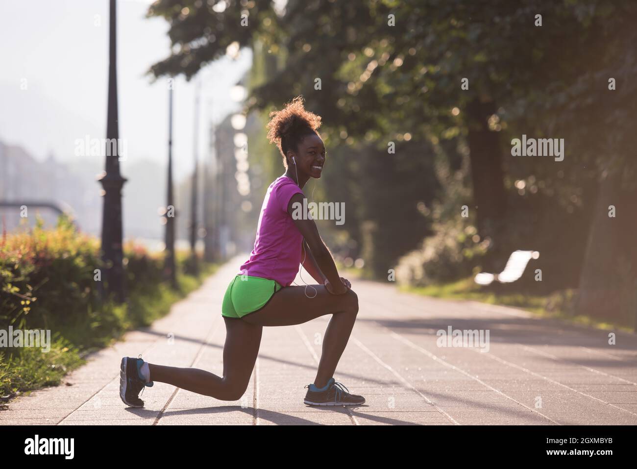 young beautiful African American woman doing warming up and stretching ...