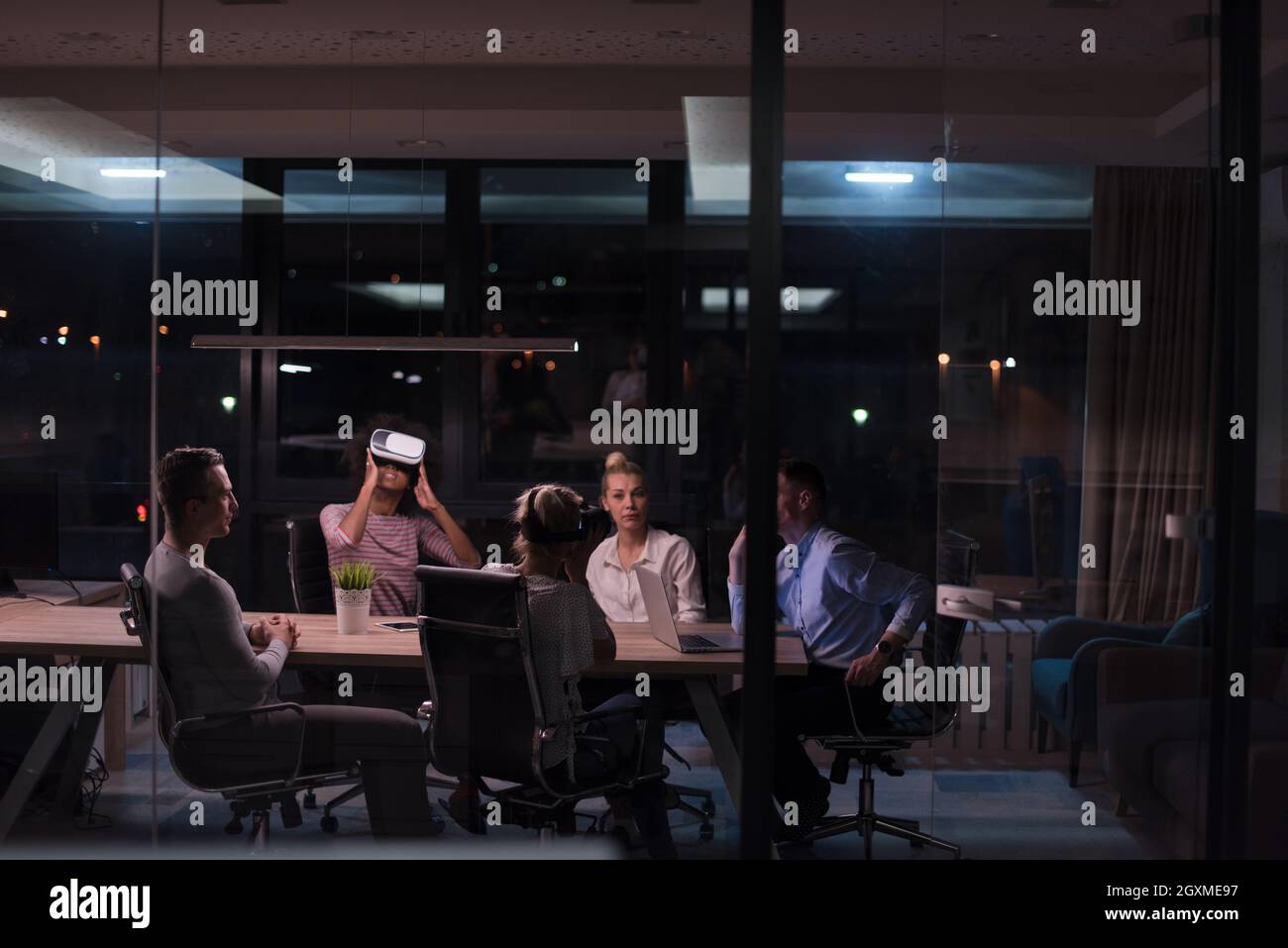 Multiethnic Business team using virtual reality headset in night office ...