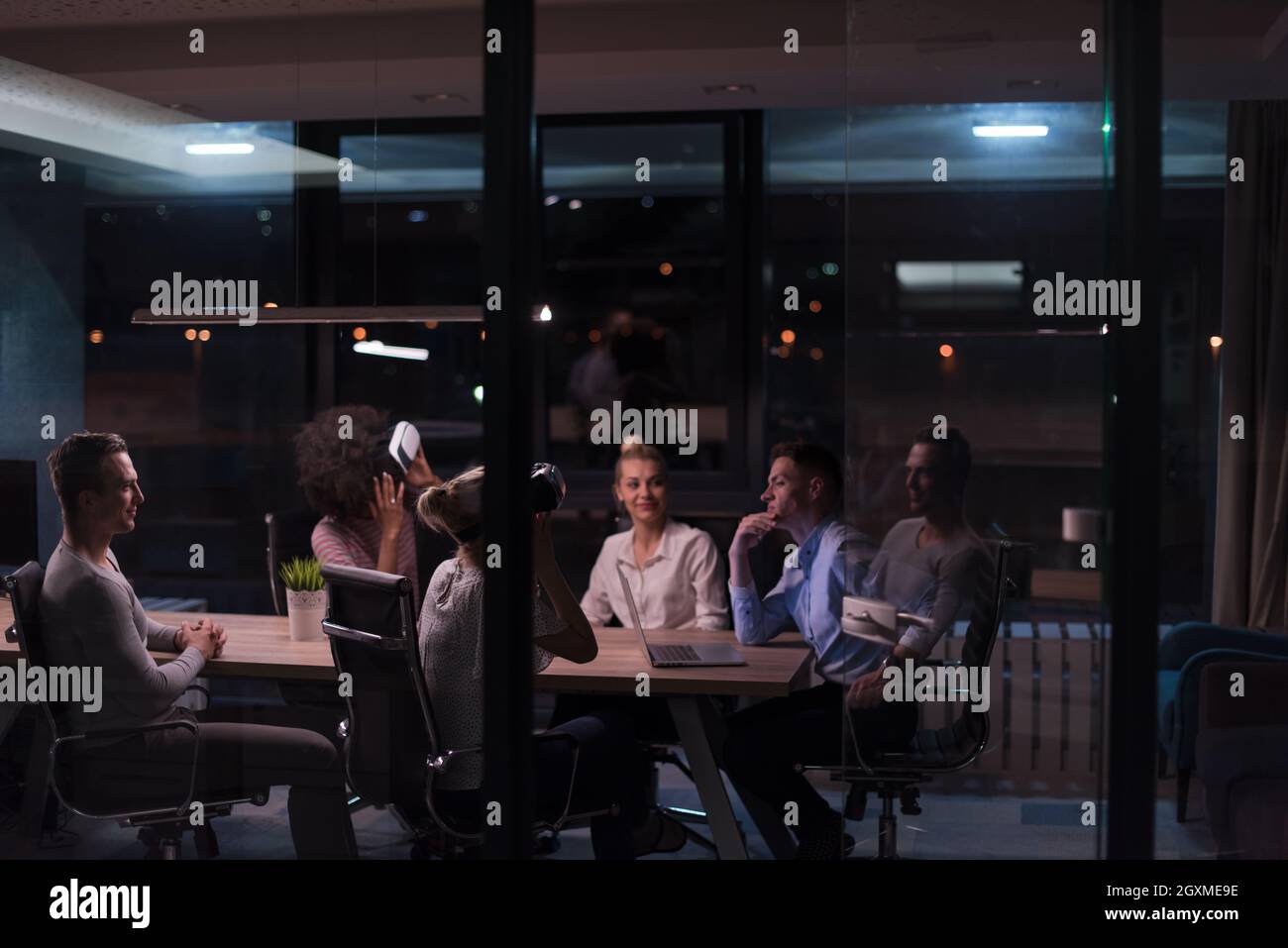 Multiethnic Business team using virtual reality headset in night office ...