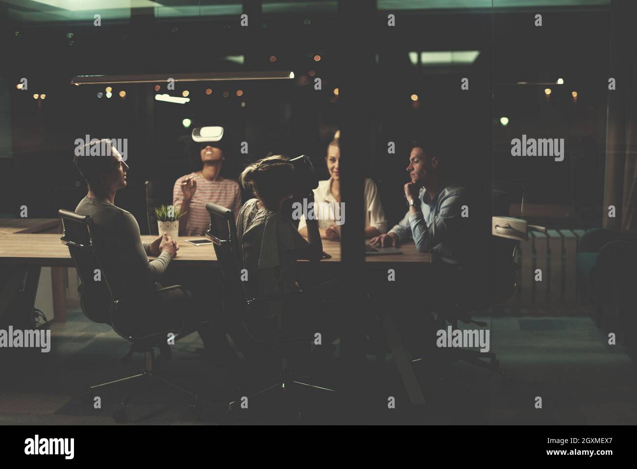 Multiethnic Business team using virtual reality headset in night office ...