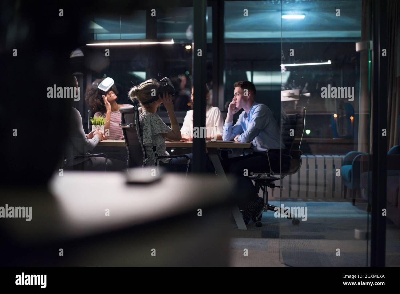 Multiethnic Business team using virtual reality headset in night office ...
