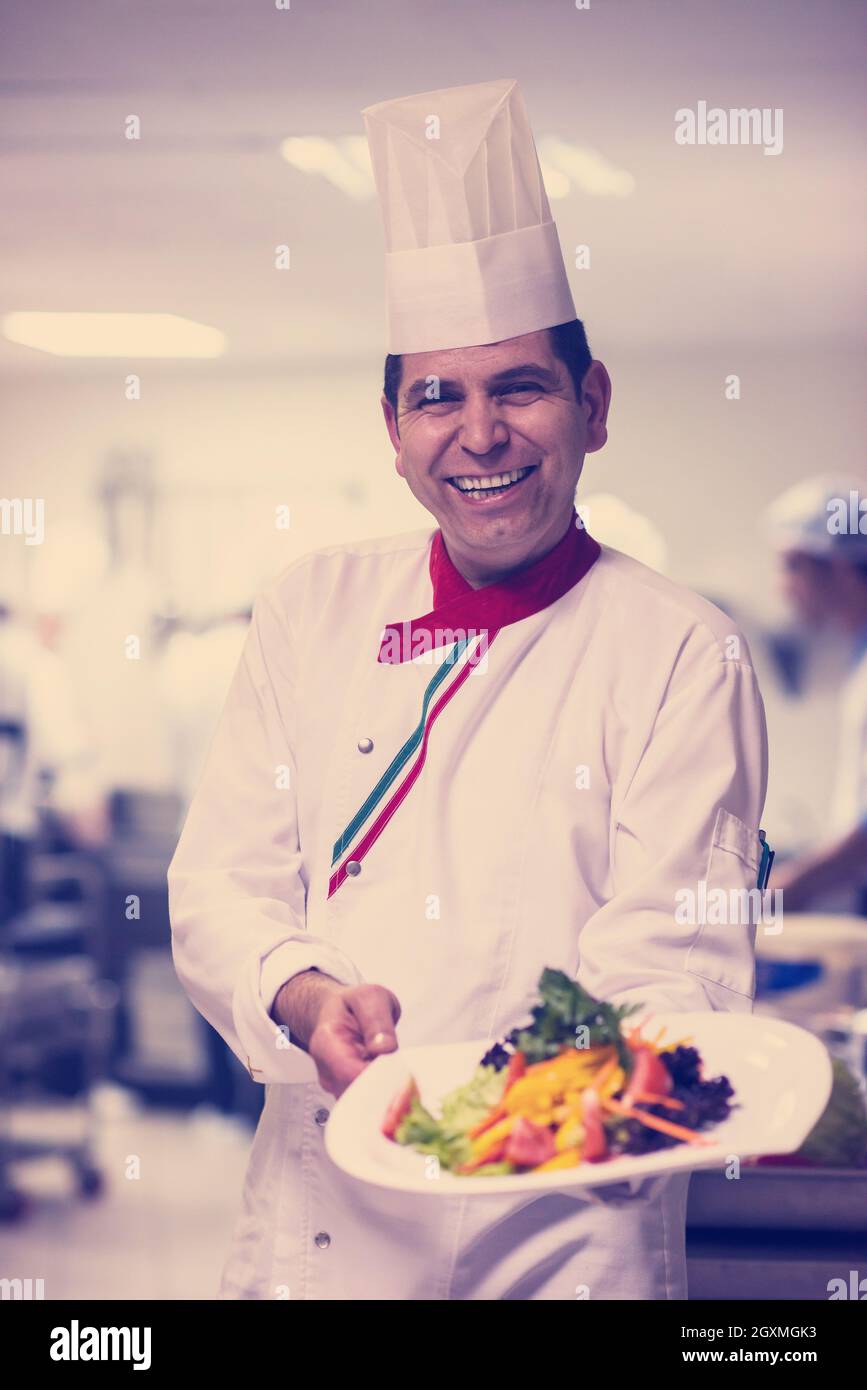 young Chef presenting a plate of tasty meal in commercial kitchen Stock ...