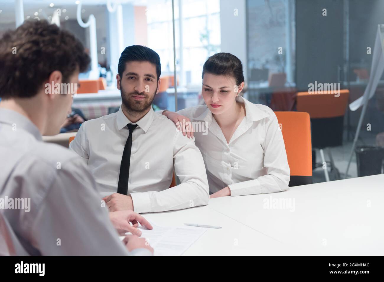 signing contract on partners back, young couple on business meeting ...