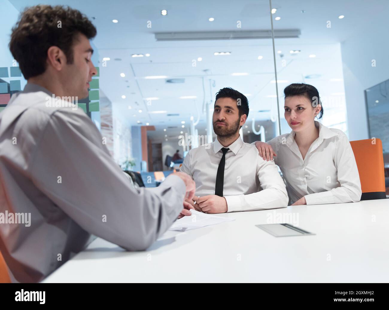 signing contract on partners back, young couple on business meeting ...