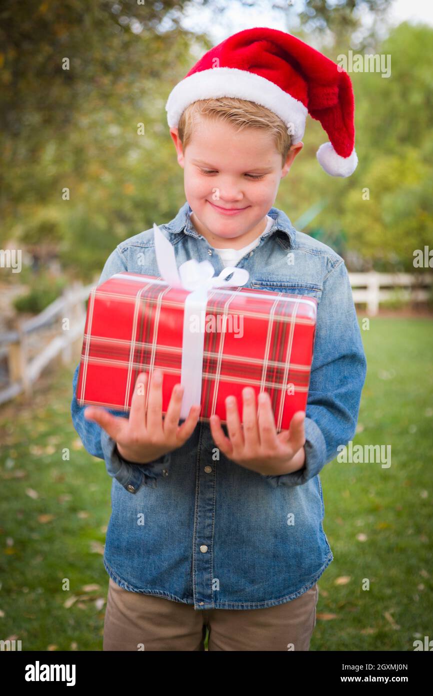 Handsome Young Boy Wearing Santa Hat Holding Christmas Gift Outside ...