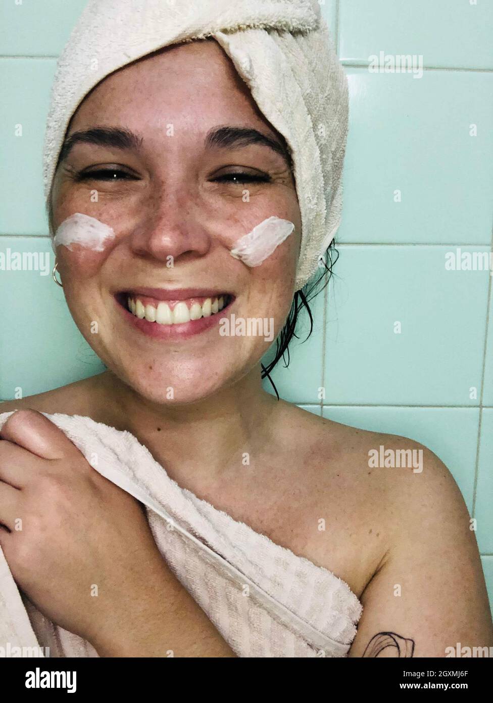 Portrait of a smiling woman with cream on her face after a shower Stock ...