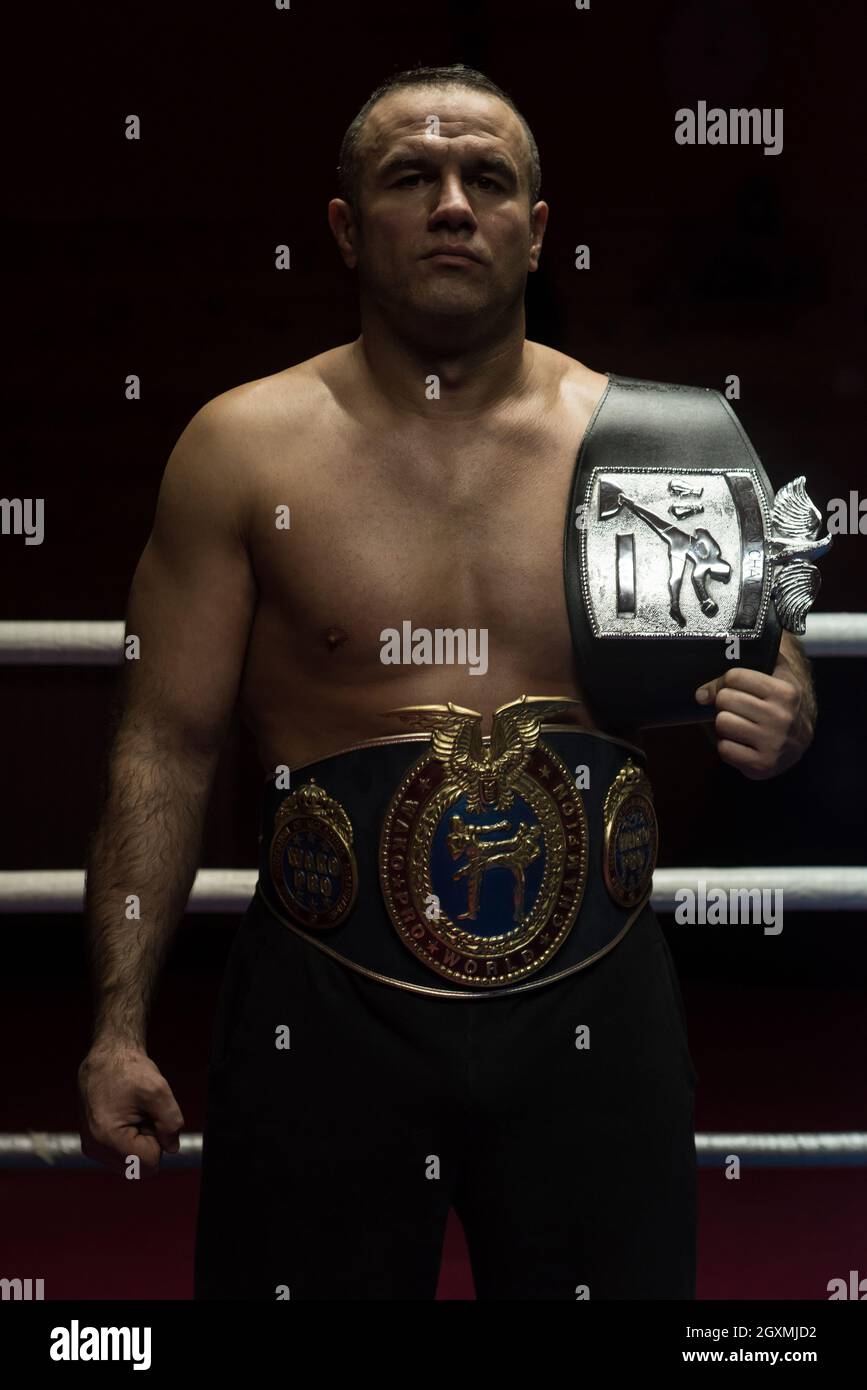 portrait of muscular professional kick boxer with his championship belt ...