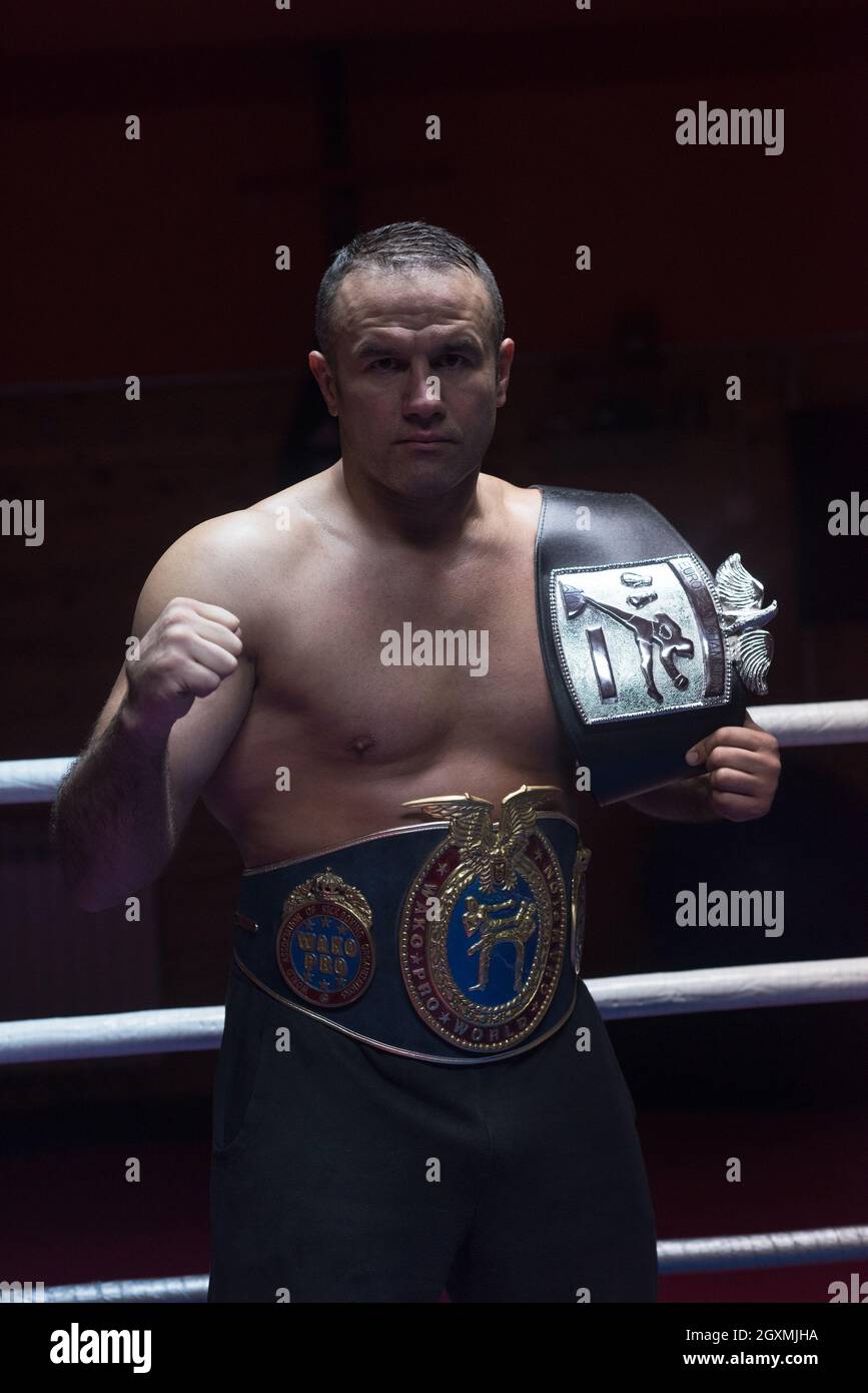 portrait of muscular professional kick boxer with his championship belt ...