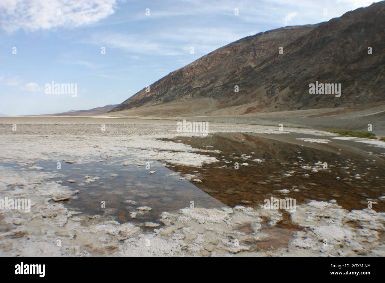 Rocky cliff face slopes down to a shallow rocky pool Stock Photo - Alamy