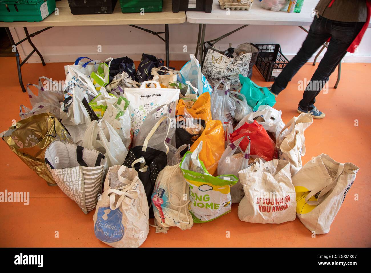 An unidentifiable volunteer at a food bank sorting crates of donated ...