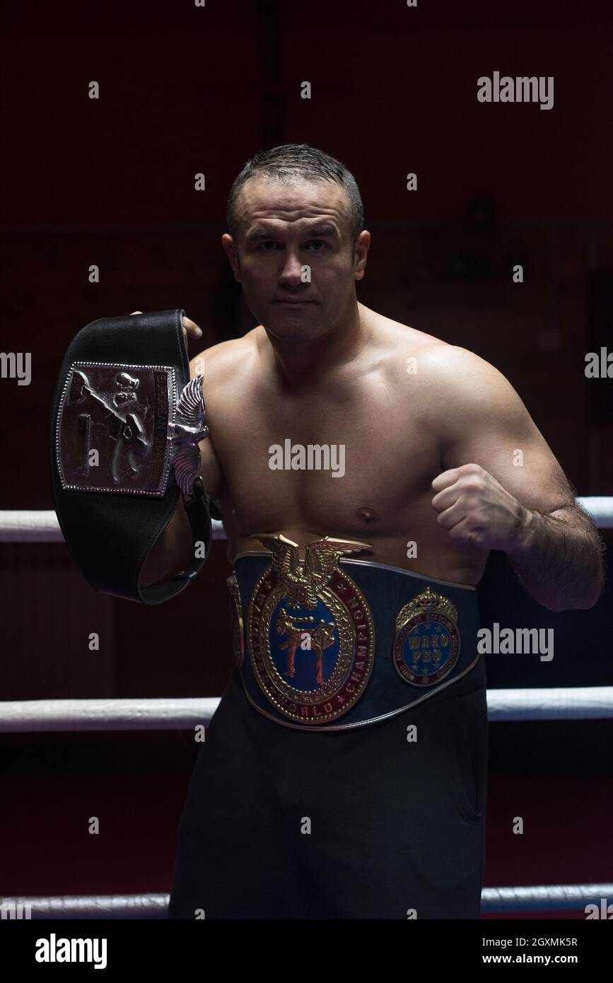 portrait of muscular professional kick boxer with his championship belt ...