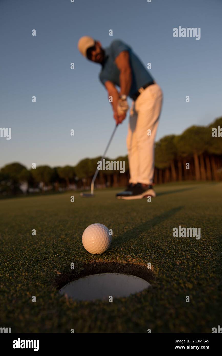 golfer hitting ball shot with driver on golf course at beautiful sunset ...