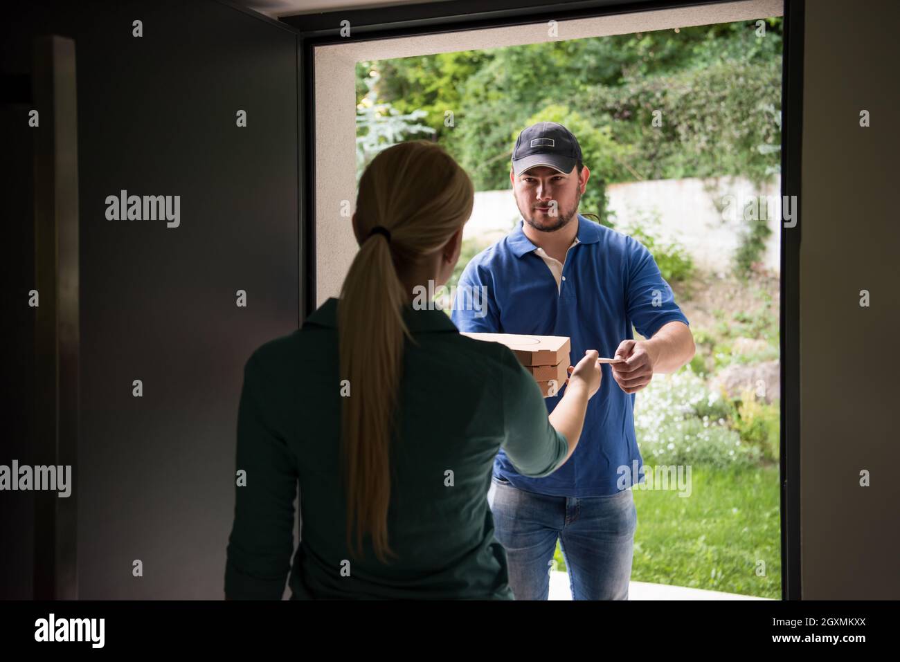 Pizza Delivery Man Giving Pizza Boxes To Smiling Young Woman Stock ...