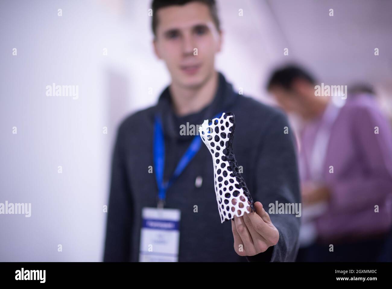 young engineer posing for the camera while showing a miniature model ...