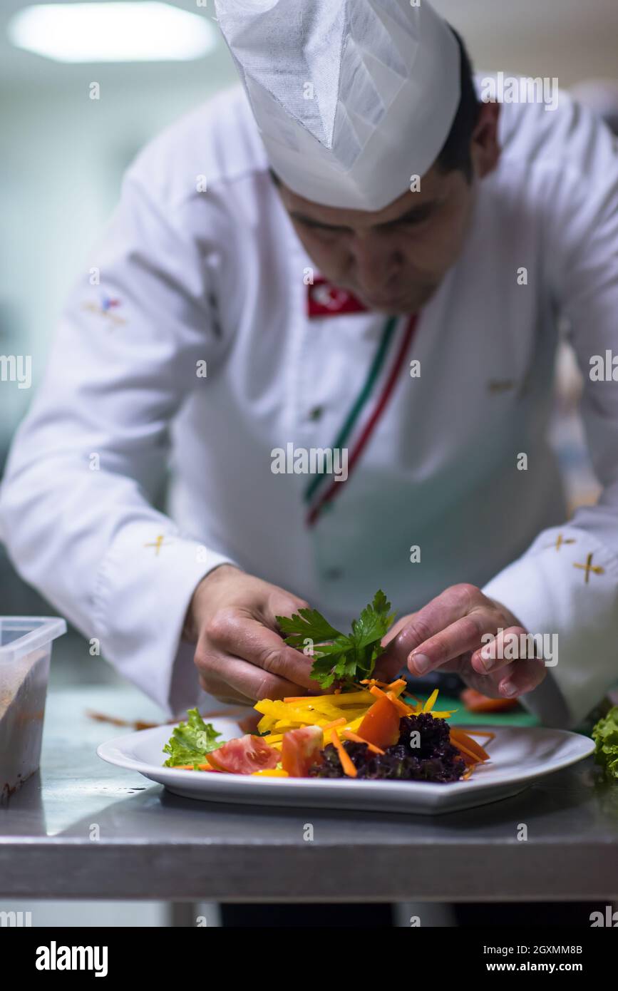 chef serving vegetable salad on plate in restaurant kitchen Stock Photo ...