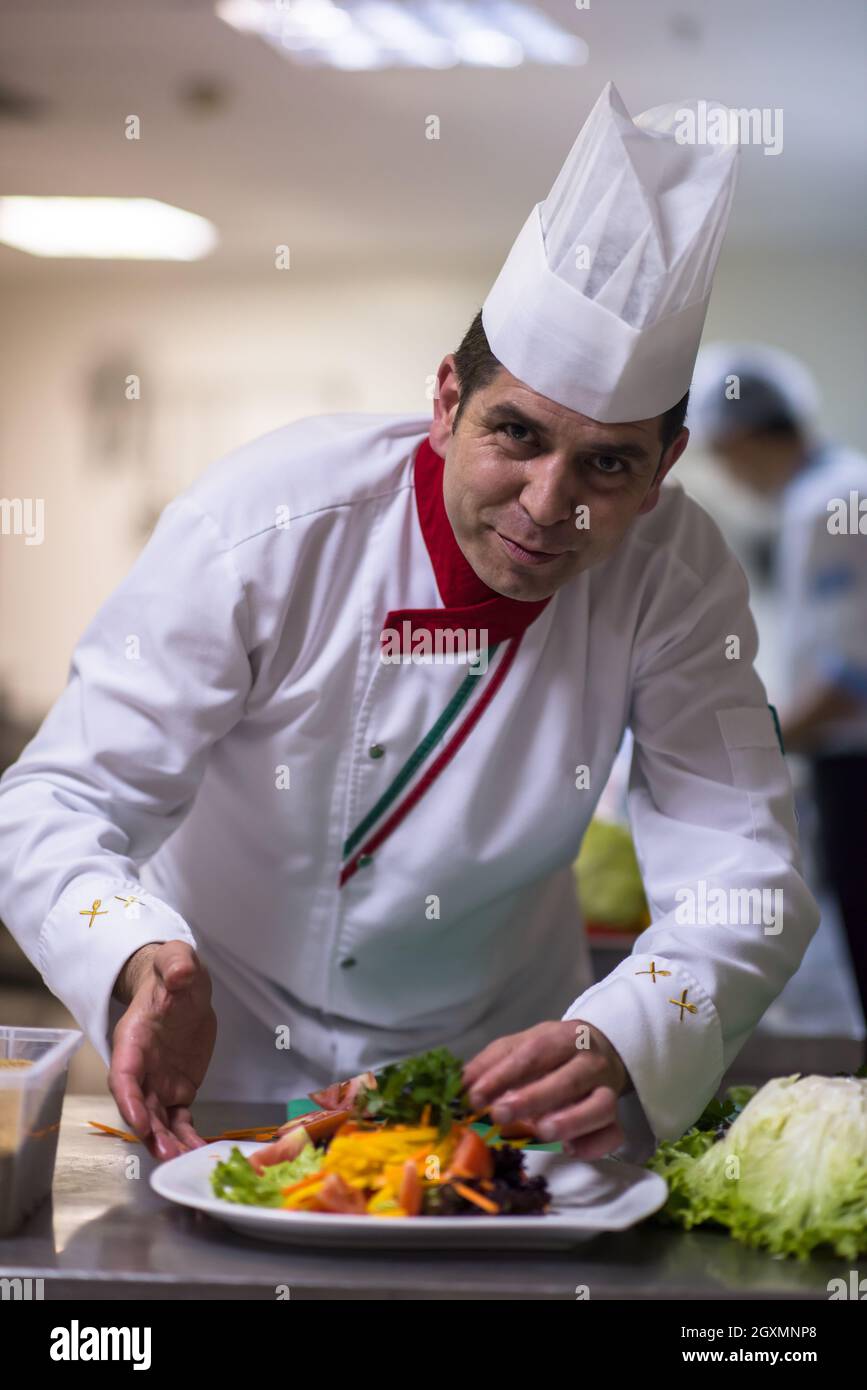 chef serving vegetable salad on plate in restaurant kitchen Stock Photo ...