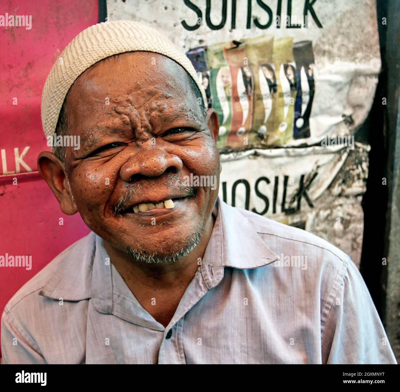 An elderly Muslim man with a smiling face full of expression wearing a ...