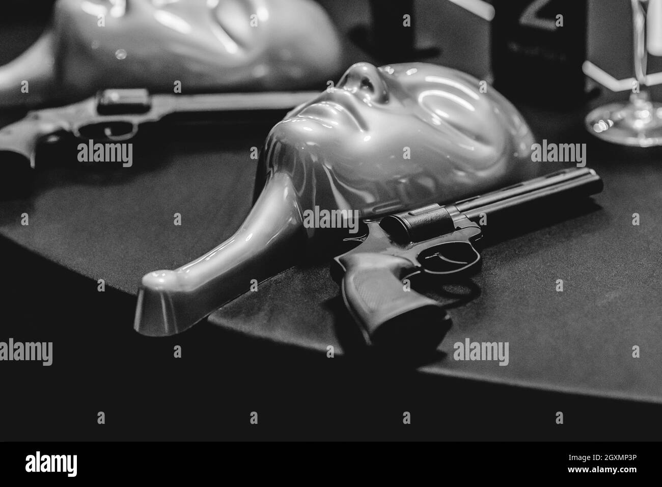 Mafia game the mask and gun on table. Black and white color filter ...