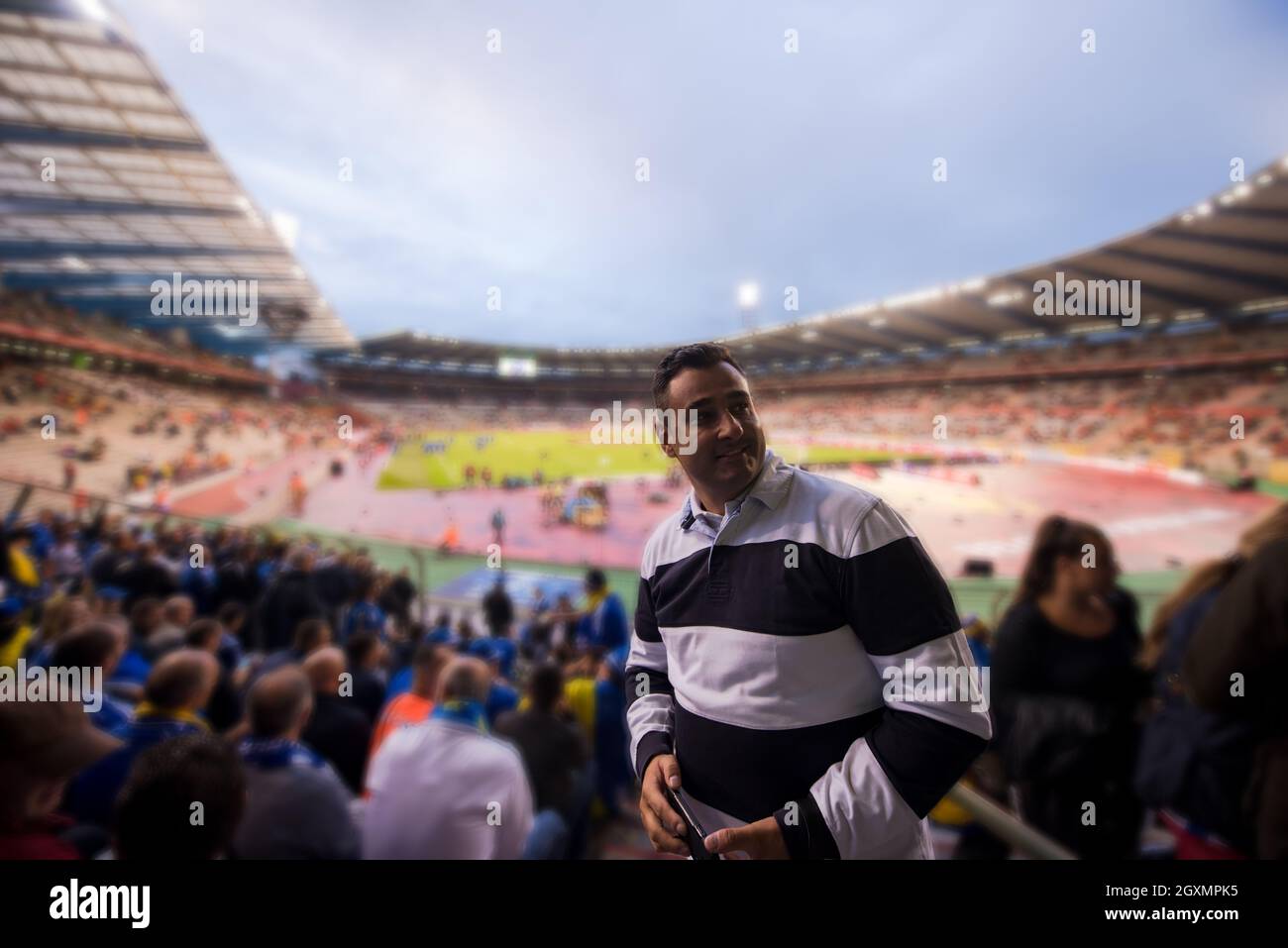 portrait of a male football fan standing on the stadium while ...