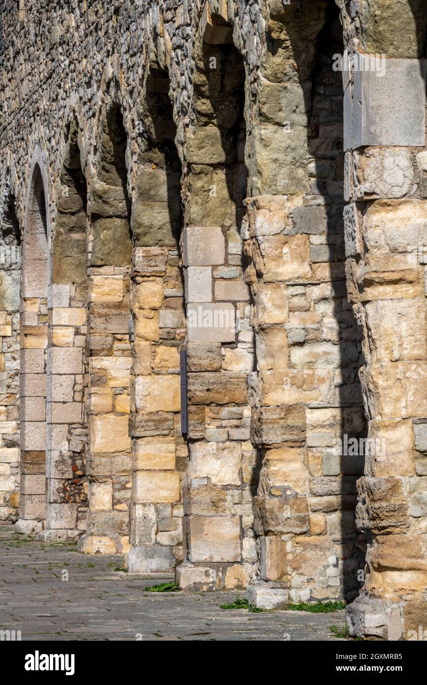 a row or line of old stone arches on the medieval historic walls of the ...