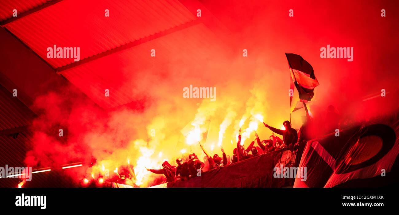 football hooligans with mask holding torches in fire while supporting ...