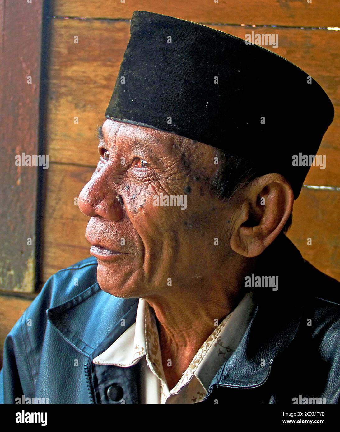 An elderly man at a traditional market wearing a songkok Moslem ...