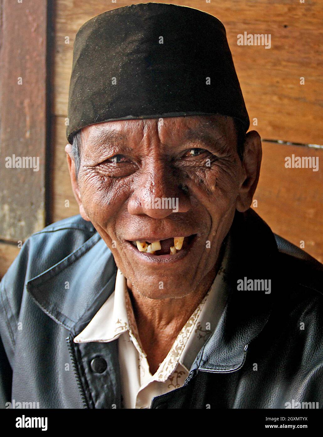 An elderly man at a traditional market wearing a songkok Moslem ...