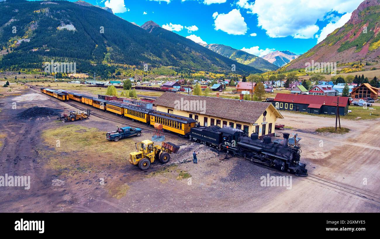 Train loading with coal in small mining town next to mountains Stock ...