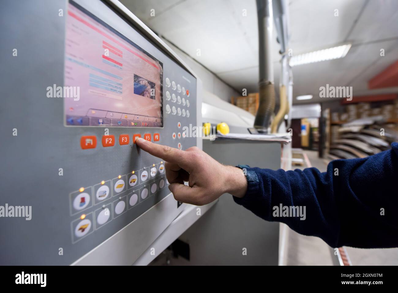 young carpenter calculating and programming a cnc wood working machine ...