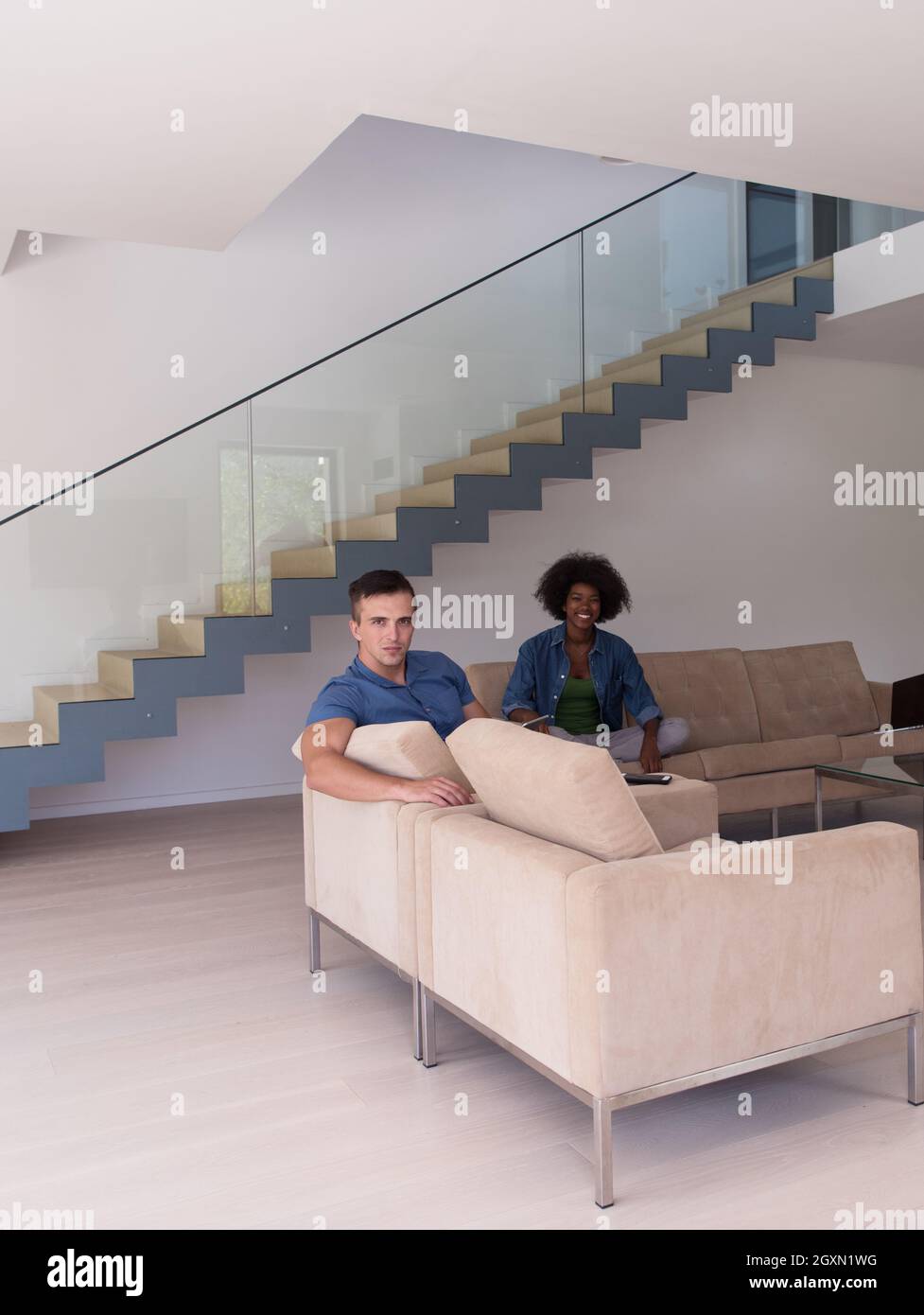 Young multiethnic couple relaxes in the luxury living room, using a ...